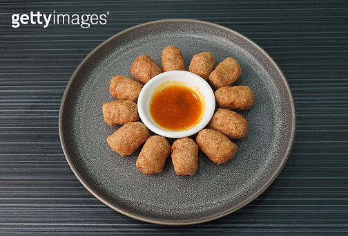 deep fried mini hot dog sausage luncheon meat with spicy sauce on dark ...