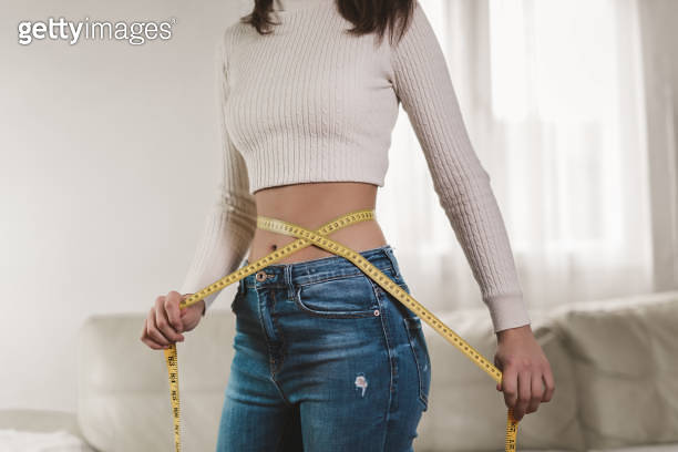 Cropped shot of a young woman measuring her waist 이미지 (1296133022) - 게티 ...