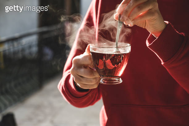 Woman mixing hot tea in cold weather. A cup of tea is steaming. 이미지 ...