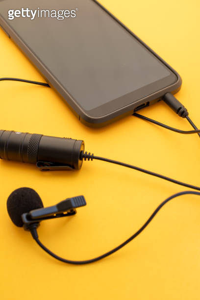 Lavalier or lapel microphone on a colored surface plugged into a cell ...