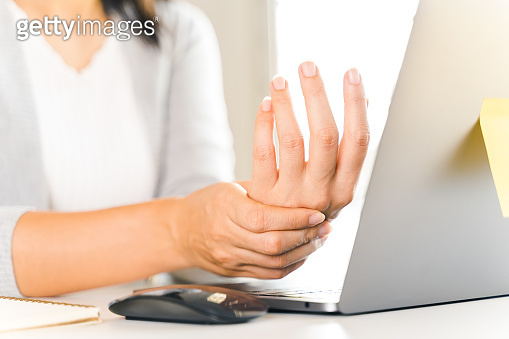 Closeup woman holding her hand pain from using computer long time ...