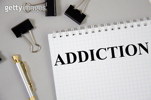 Addiction word written on gray background with pencils and paper clips ...