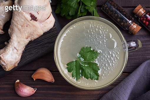 Chicken broth in a glass Cup. Boiled chicken leg quarters. Healthy food ...