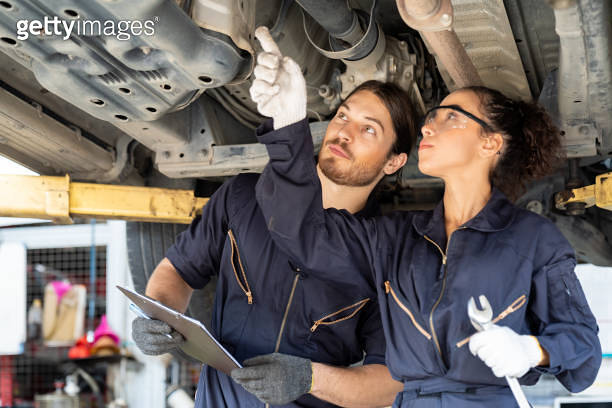 Male and female car mechanic worker working using wrench tool for ...