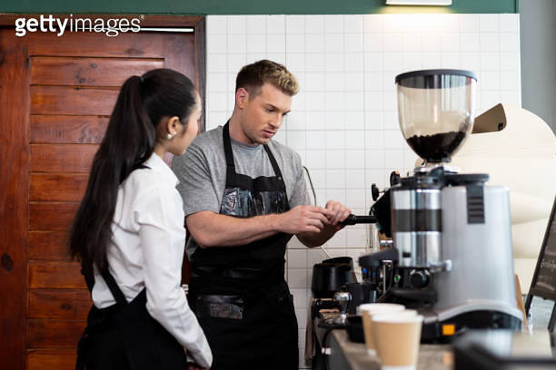 Barista cafe wearing apron and prepare coffee grinder pour at coffee ...