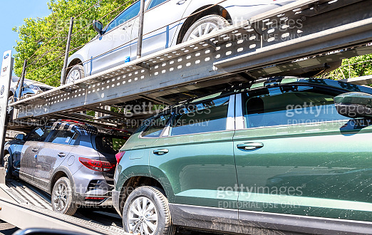 Car transporter carries vehicles on a freeway, back view of the trailer ...