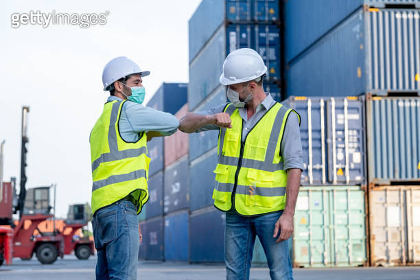 Two cargo container workers or engineer men show greeting together with ...