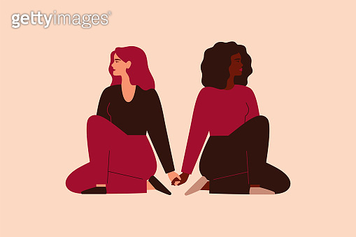 Two strong women sit together and hold arms. Fearless girls support and ...