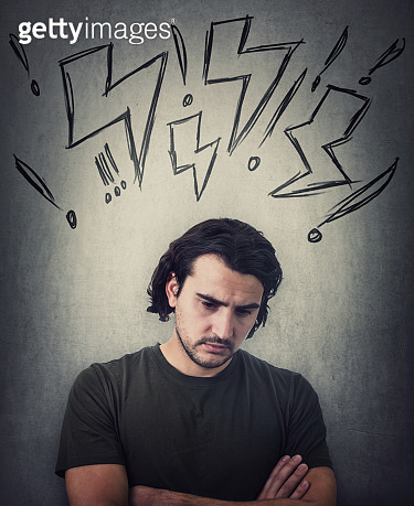 Annoyed man makes a displeased facial expression, arms crossed looking ...