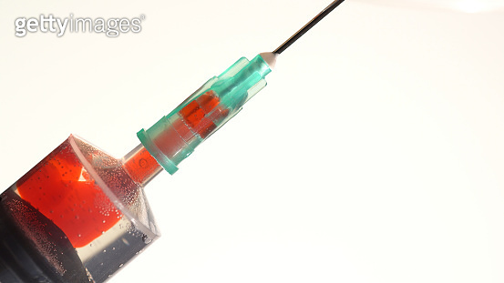 Syringe close up taking mixing blood of a patient with drug and ...