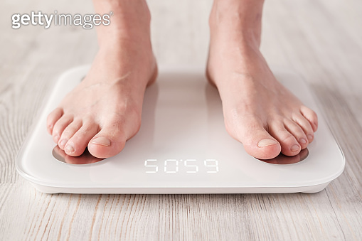 Bare feet stand on smart scales that makes bioelectric impedance ...
