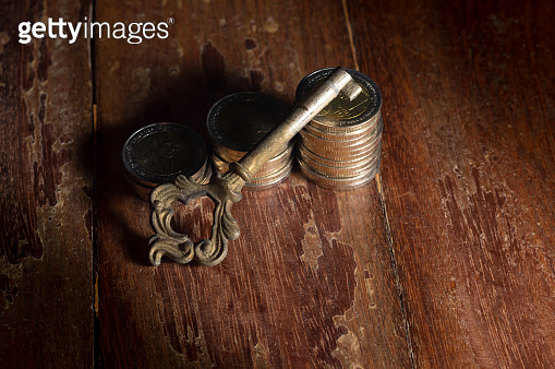 Old key with stacked of money coins.No trade mark or invalid sign on ...