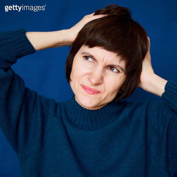 Portrait of mature woman in distress, close-up. Agitated tensed face ...