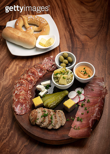 german cold cuts tapas snack platter with meats and bread on wood table ...