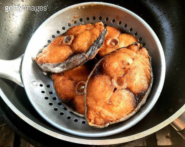Frying King Mackerel Fish in Colander and Cooking pan. (1351452893 ...