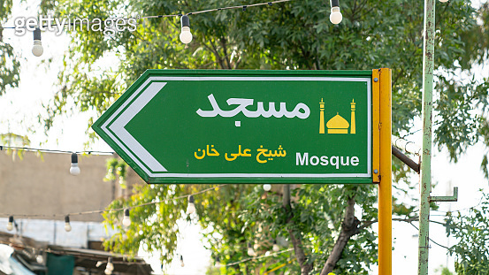 Street sign indicating the direction to a Muslim mosque in Iran. Arabic ...