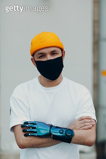 Young disabled man with artificial prosthetic hand wearing medical ...