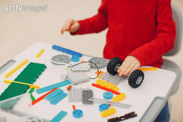 Smiling kid child constructor checking technical toy. Children Robotics ...