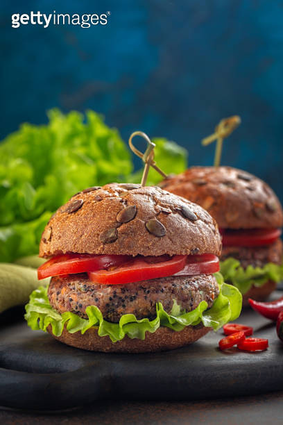 Close-up of veggie burger made from quinoa, beans, peanut sauce, salad ...