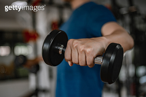Training gym concept a young adult using his muscular strong arm ...
