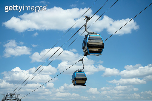 Cable car cabins against amazing sky and clouds. Cableway, green ...