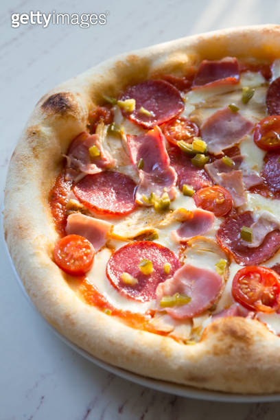 Whole baked neapolitan pepperoni pizza on a table (1333400160) - 게티이미지뱅크