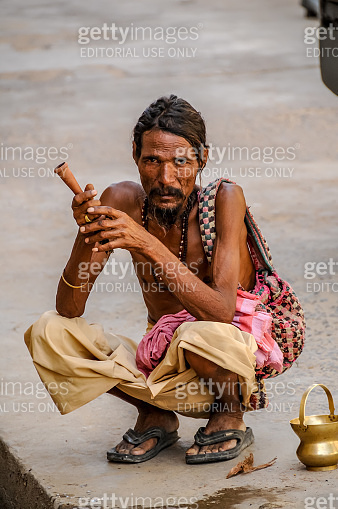 Crouching Indian sadhu smokes from a cilum. (1347769281) - 게티이미지뱅크