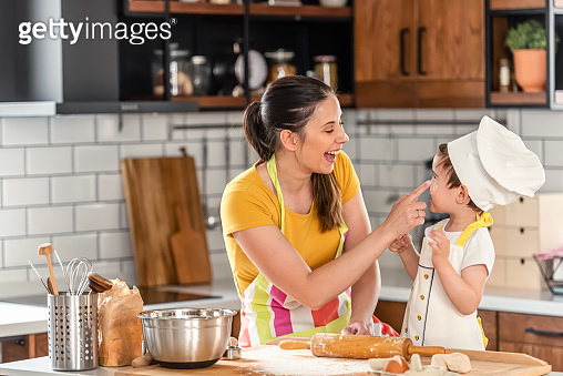 Mother baking cake in the kitchen with her cute toddler son. Mother and ...