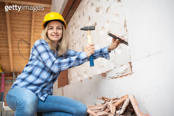 pretty young worker woman with blue work shirt and yellow protective ...