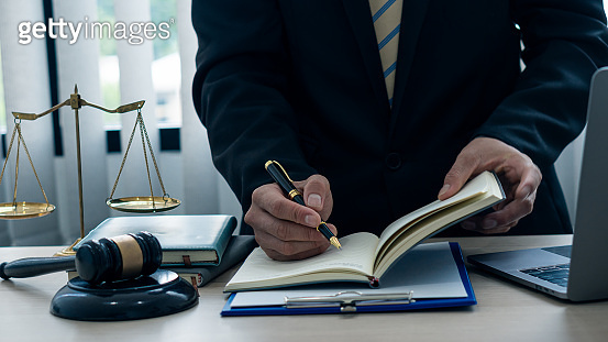 A lawyer or judge works in the office handing the paperwork with a ...