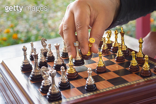 A man's hand is hitting the rook with the queen in a chess game ...
