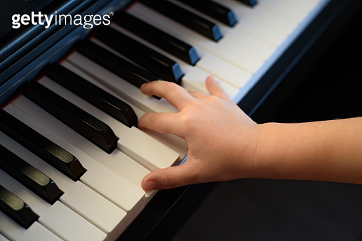 A child's hand presses the piano keys. Early musical development in ...