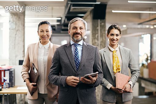 Happy CEO and his female colleagues standing at corporate office and ...
