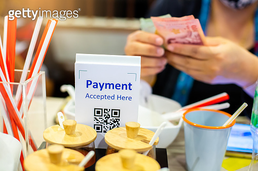 QR code tag with blurry food and customer is counting the banknotes in ...