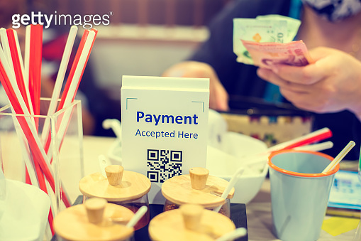 QR code tag with blurry food and customer is counting the banknotes in ...