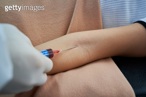 Closeup to needle injection on arm of women patient in hospital ...