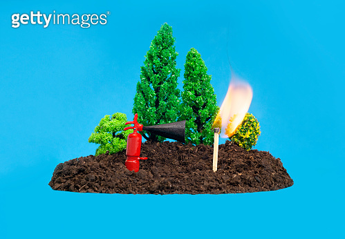 Miniature toy forest setup with a tiny fire extinguisher next to a ...