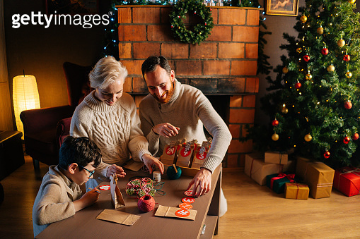 High-angle view of young family making Christmas advent calendar ...