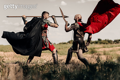 Battle between two ancient warriors in battle dress and cloaks. 이미지 ...
