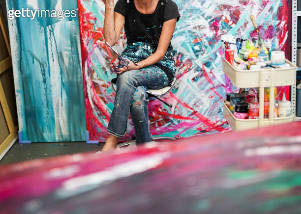 Caucasian artist woman sitting with masterpiece abstract oil painting ...