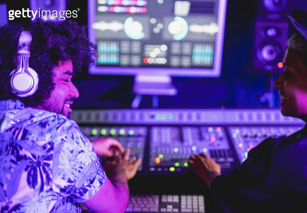 Sound engineer and musician recording song in inside recording studio ...