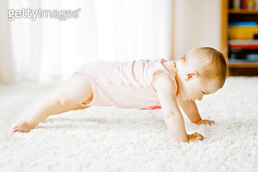 Adorable crawling baby girl portrait at home. Little funny child ...