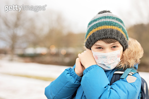 Kid boy wearing ffp medical mask on the way to school. Child backpack ...