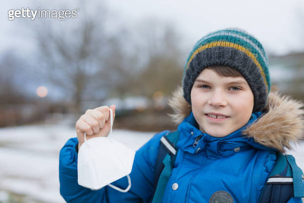 Kid boy wearing ffp medical mask on the way to school. Child backpack ...