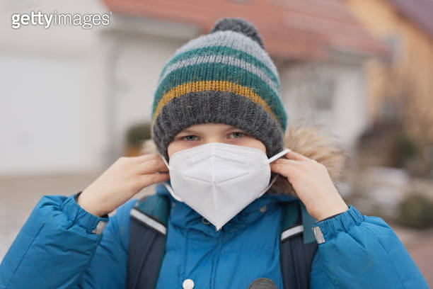 Kid boy wearing ffp medical mask on the way to school. Child backpack ...