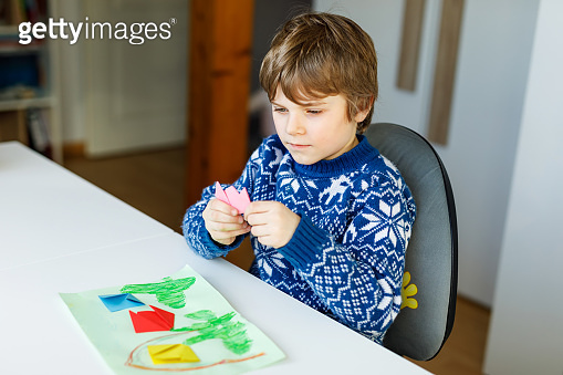 Little kid boy making paper origami tulip flowers for a postcard for ...