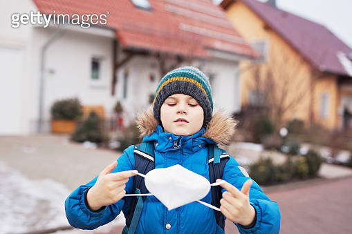 Kid boy wearing ffp medical mask on the way to school. Child backpack ...