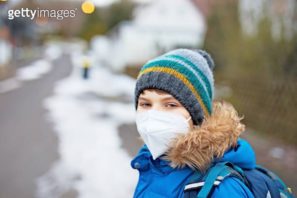 Kid boy wearing ffp medical mask on the way to school. Child backpack ...