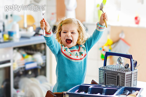 Cute little toddler girl helping in the kitchen with dish washing ...