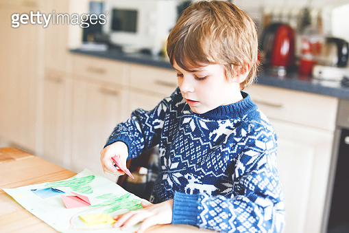 Little kid boy making paper origami tulip flowers for a postcard for ...